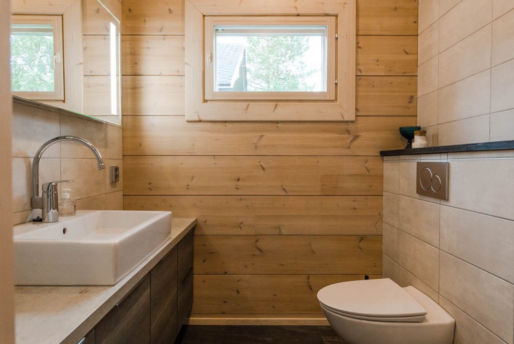 Toilet in a cosy wooden log house made in Rovaniemi. – Aito Log Houses
